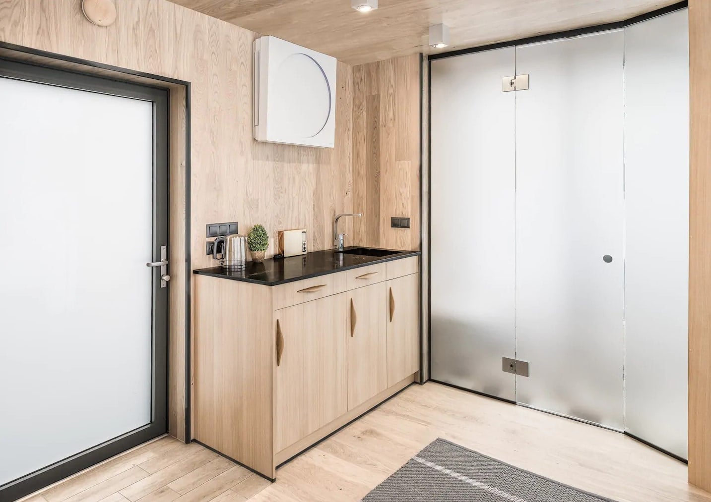 Lakeside Tiny House in Estonia with Over-sized Reflective Windows